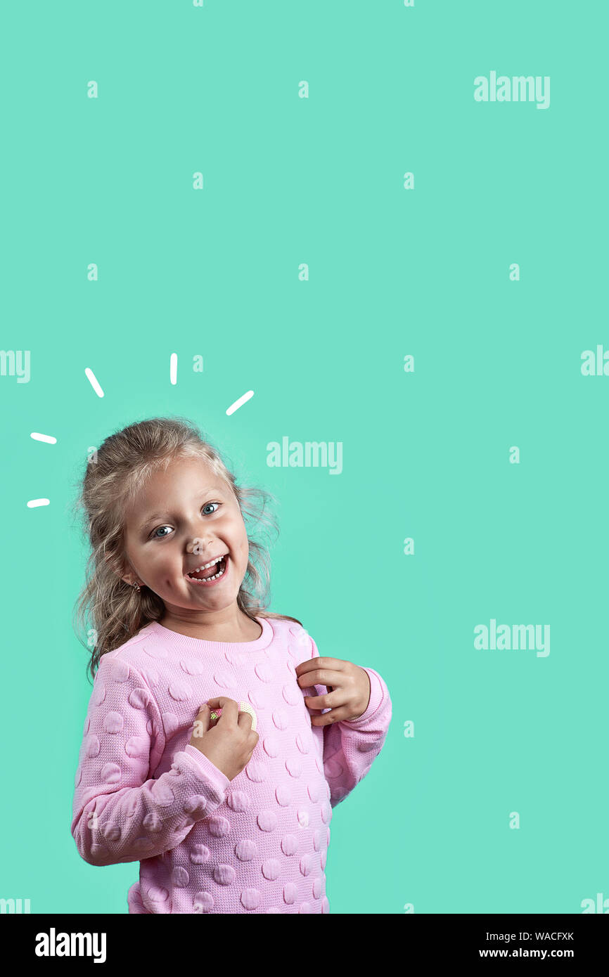 A cute cheerful girl with dimples on her cheeks and curly hair smiles ...