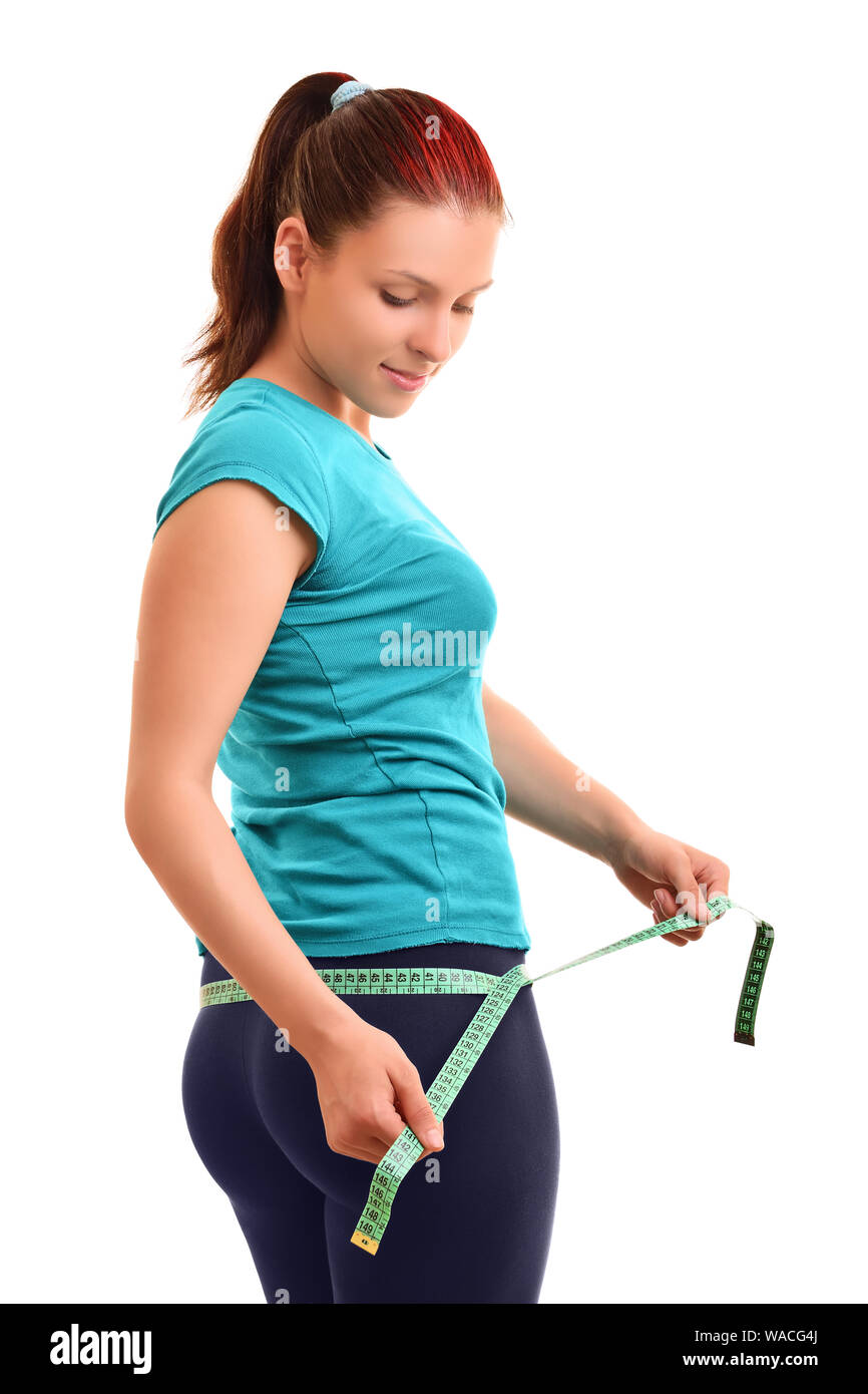 Beautiful fit young woman in sports outfit measuring her hips with a ...