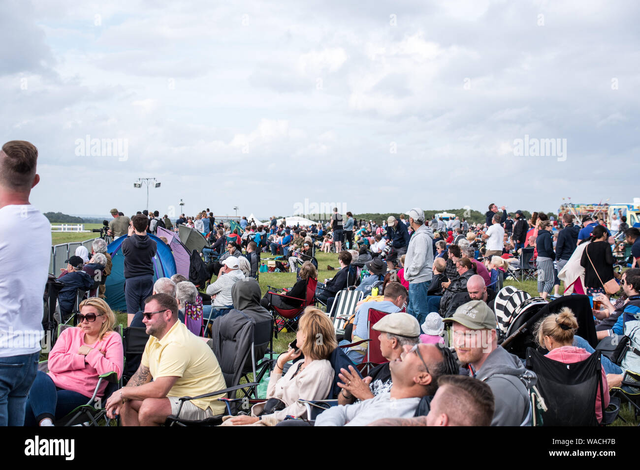 A large crowd of spectators at an airshow behind the fence (EDITORIAL ...