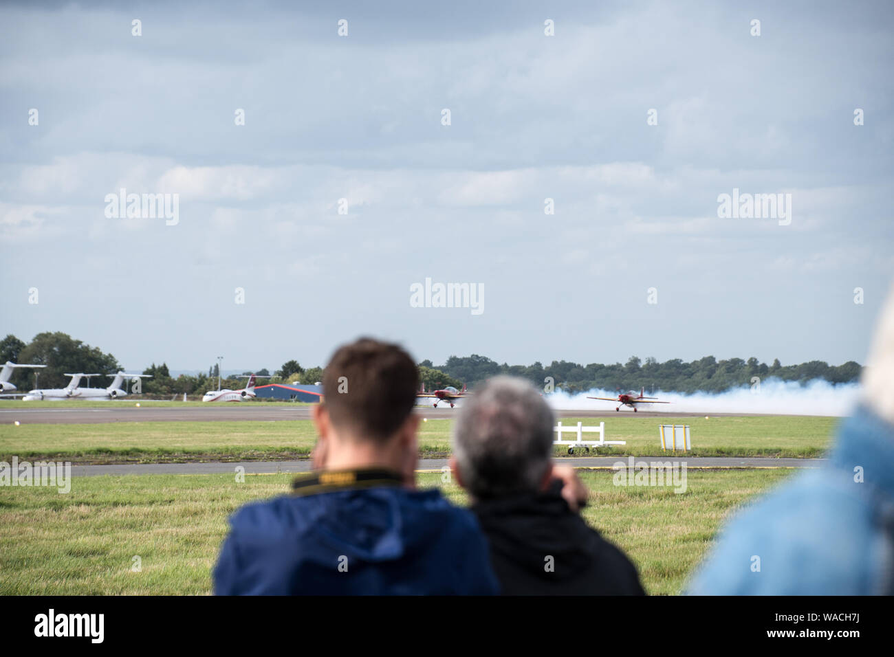 Spectators at airshow taking pictures of aircraft performance ...