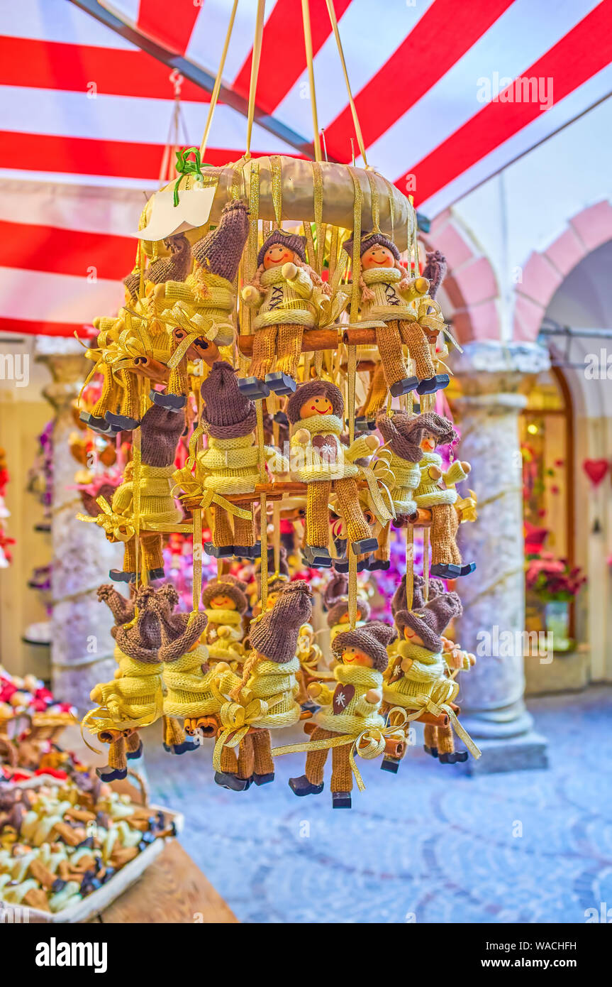 The small toys in knitted clothes on a swings at the outdoor stall of ...