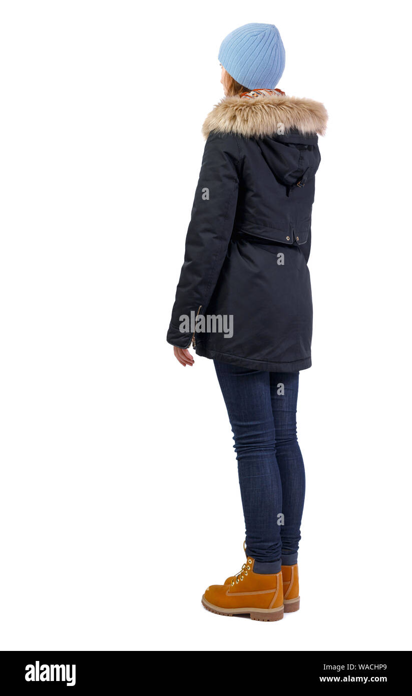Back view woman in a black winter jacket with fur and blue hat ...