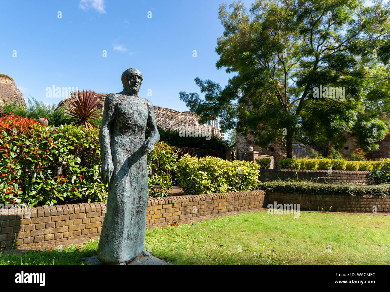 Statue of a robed woman by Elisabeth Frink in a walled garden near the ...