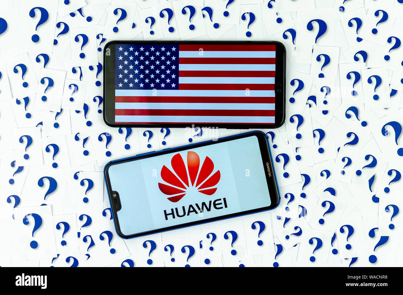 HUAWEI logo and American flag on the smartphones and a lot of cut paper ...