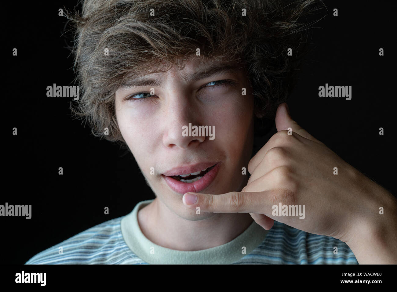 young guy showing a call me sign gesture finger, symbol of mobile phone ...