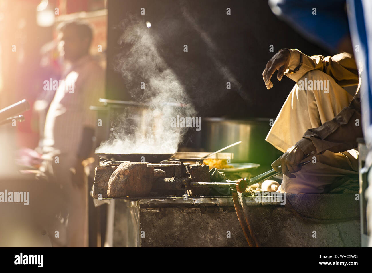 An Indian elderly man is cooking Chapati on the streets of Jaipur ...