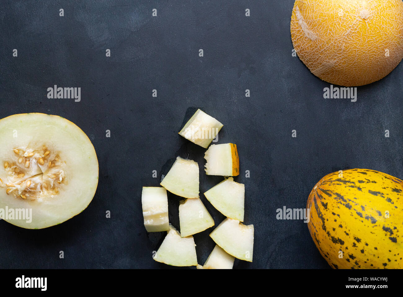 top view of fesh melon sliced pieces, cut on a black surface Stock ...