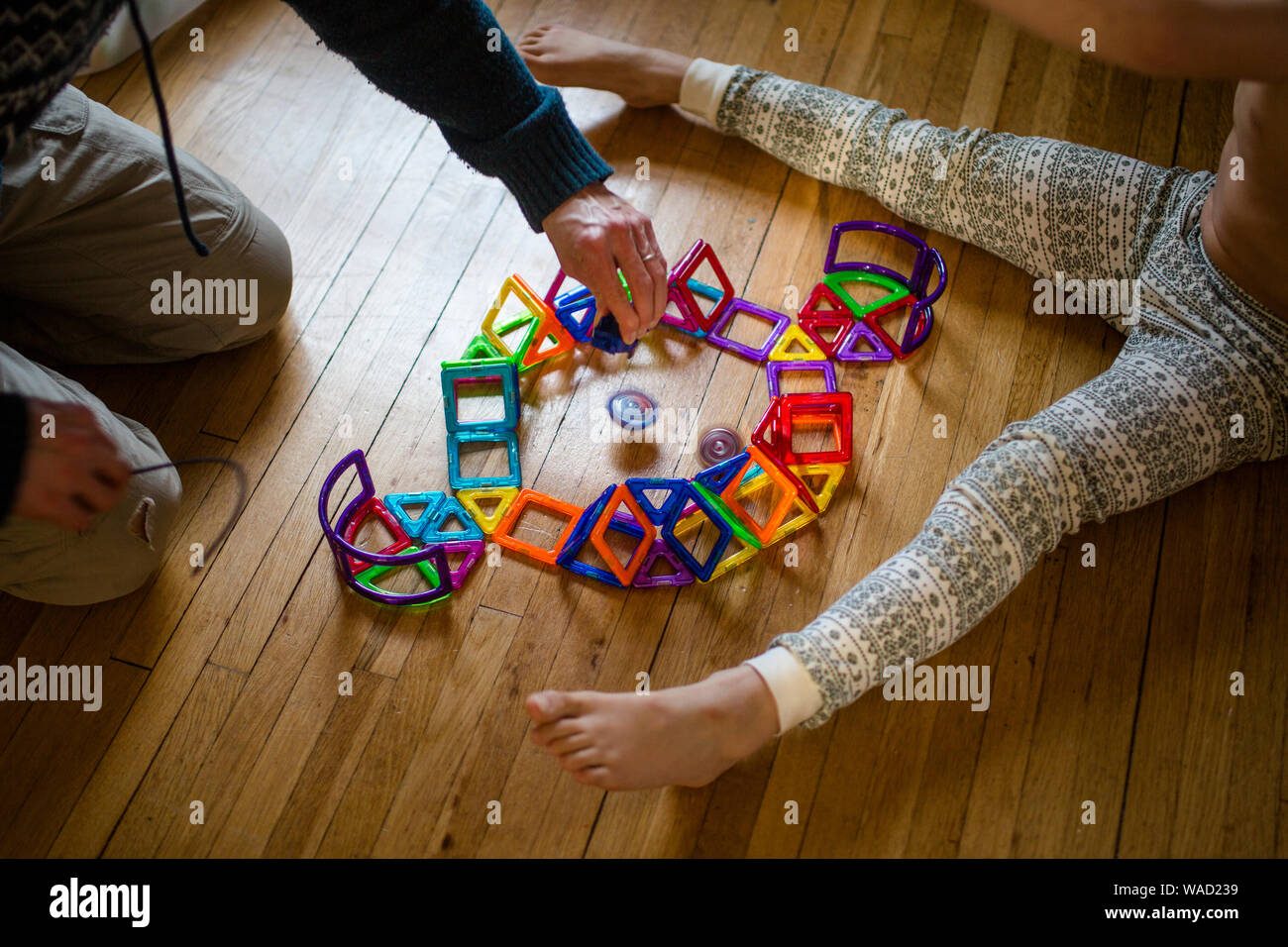 A father and child play spinning tops in a hand-constructed arena Stock ...