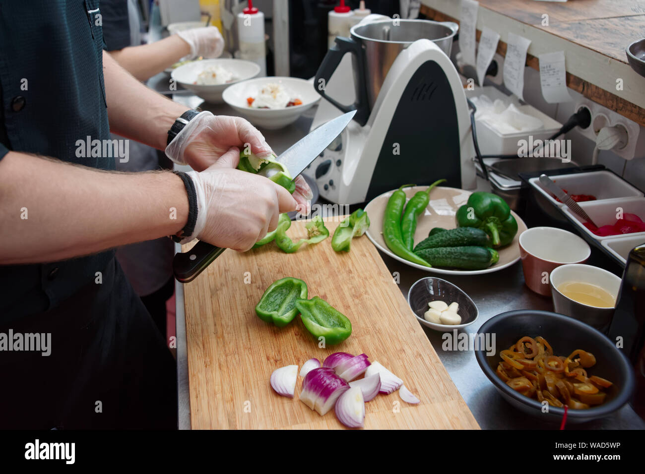 Chef is cutting vegetables at commercial kitchen Stock Photo - Alamy