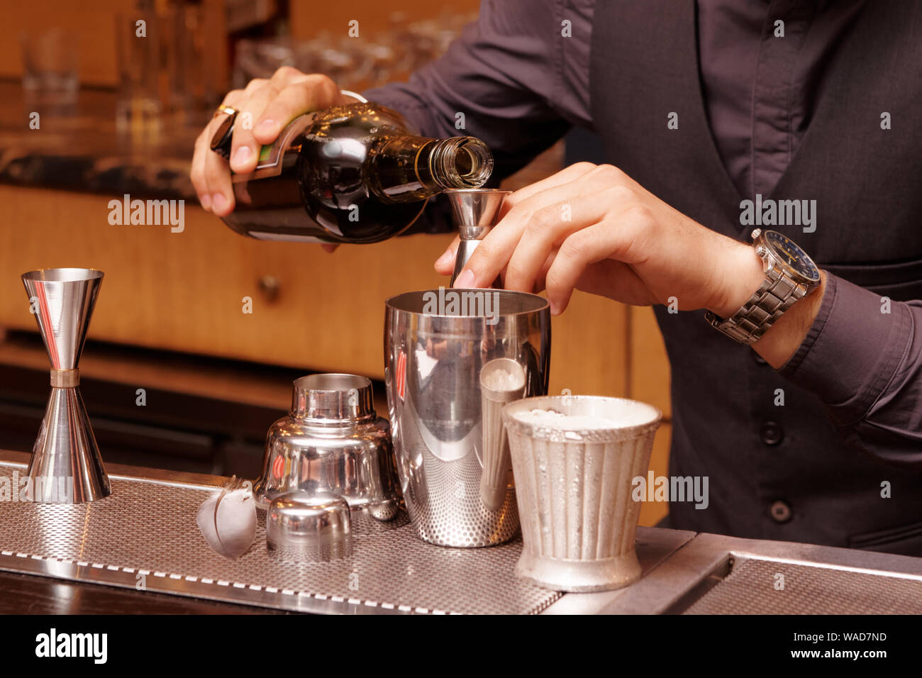 Bartender is pouring alcohol into a mixing glass Stock Photo - Alamy