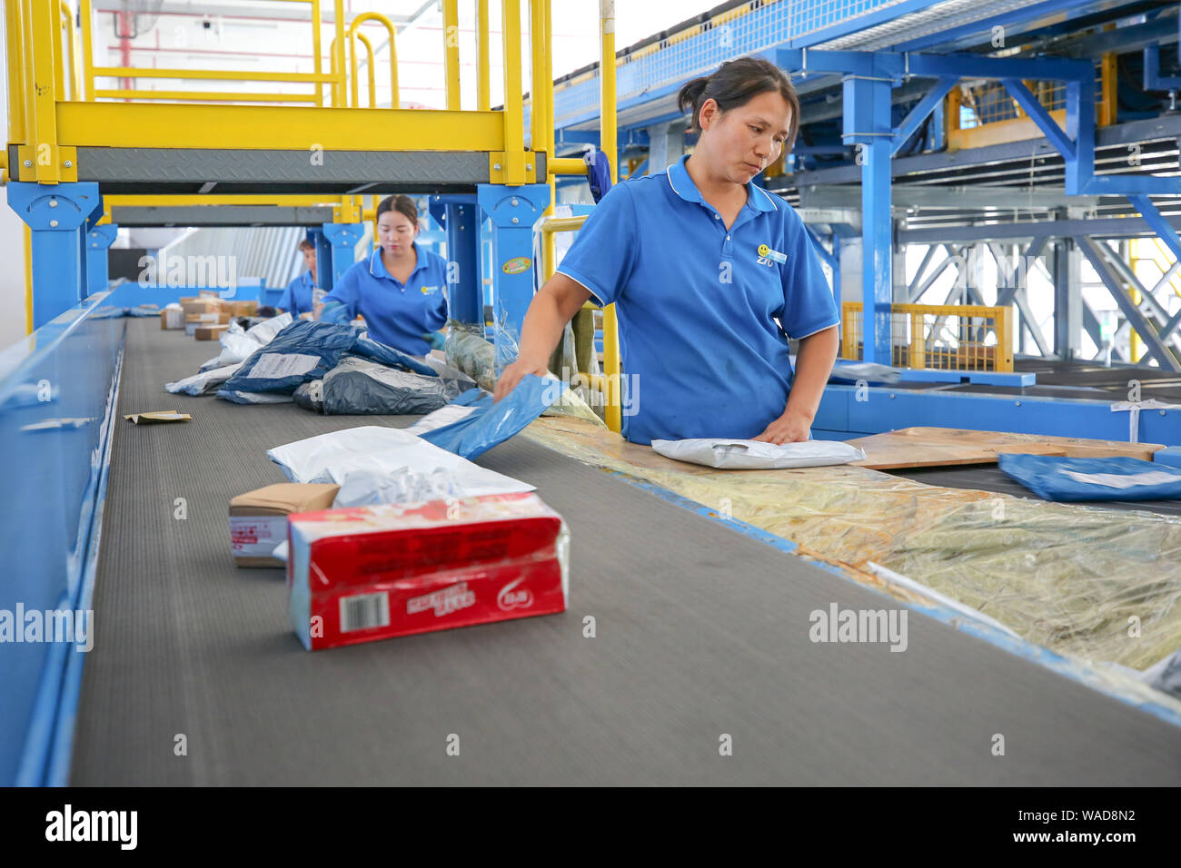Employees work along assemble line to dispatch packages with computer ...