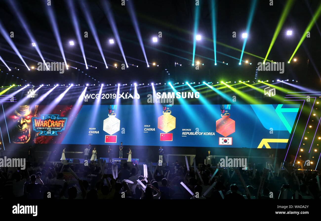 China's 2009 champion Wang "Infi" Xuwen, center, poses with his gold medal after winning ...