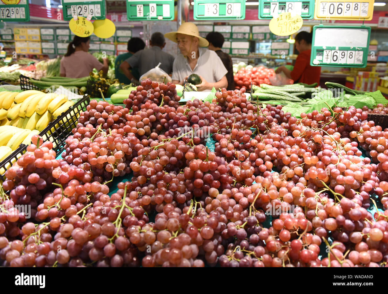 Chinese customers shop for fruits at a supermarket in Linquan county ...