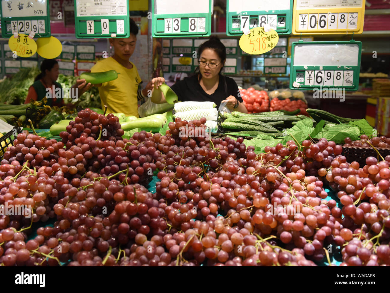 Chinese customers shop for fruits at a supermarket in Linquan county ...