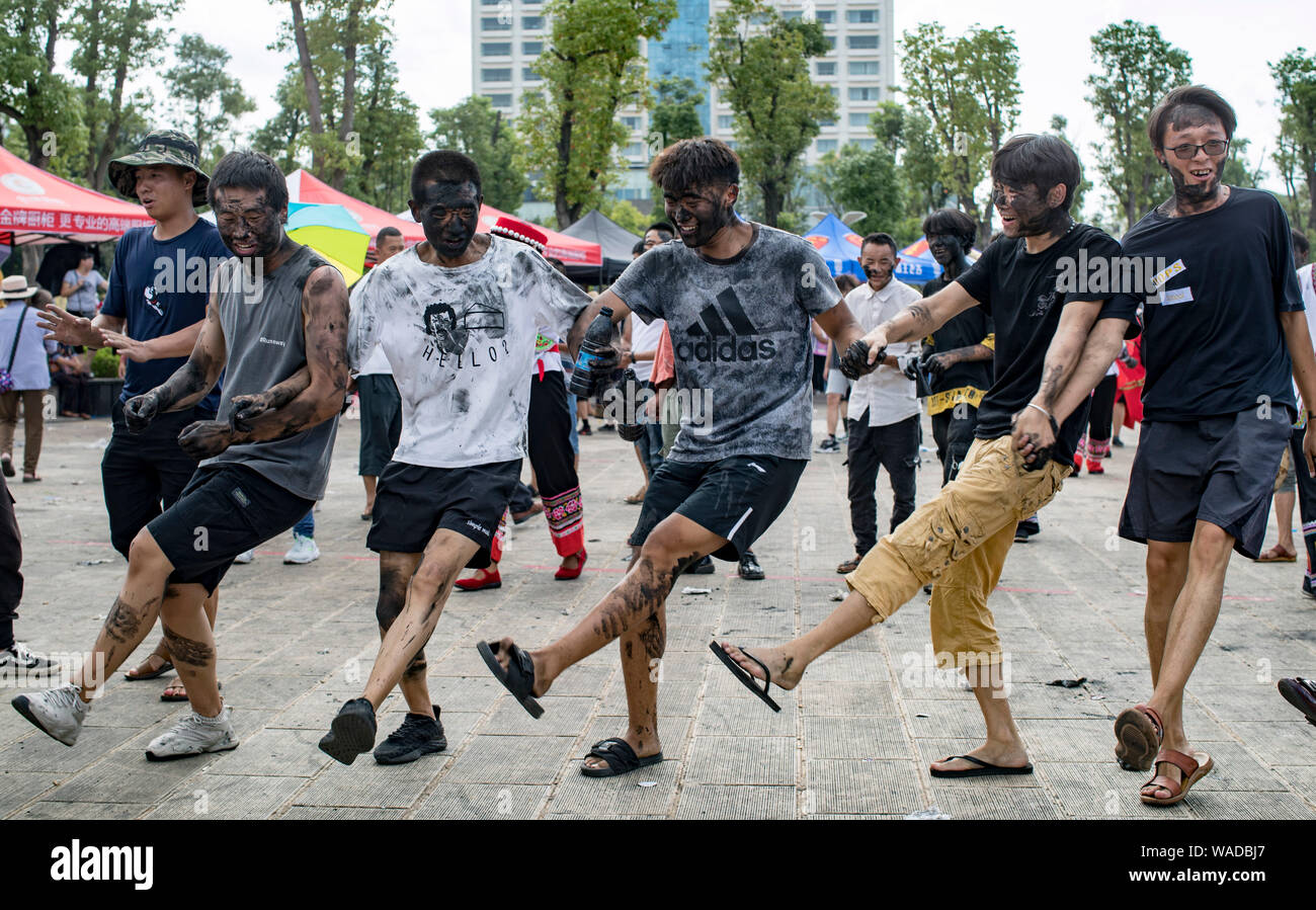 Chinese people of the Yi ethnic group daub their faces black to ...