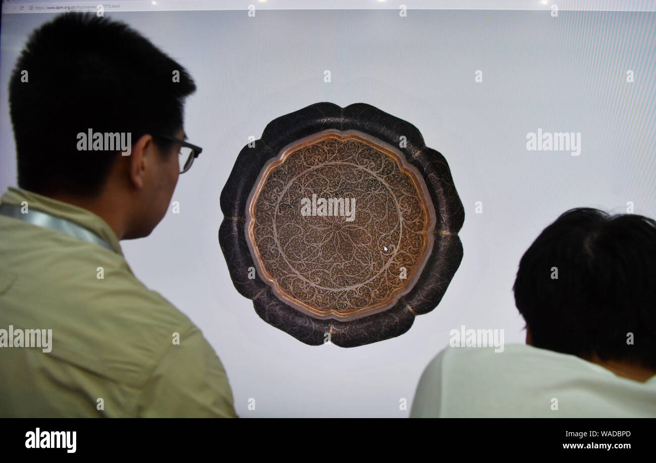 Visitors view a digital product at the Palace Museum, also known as the ...
