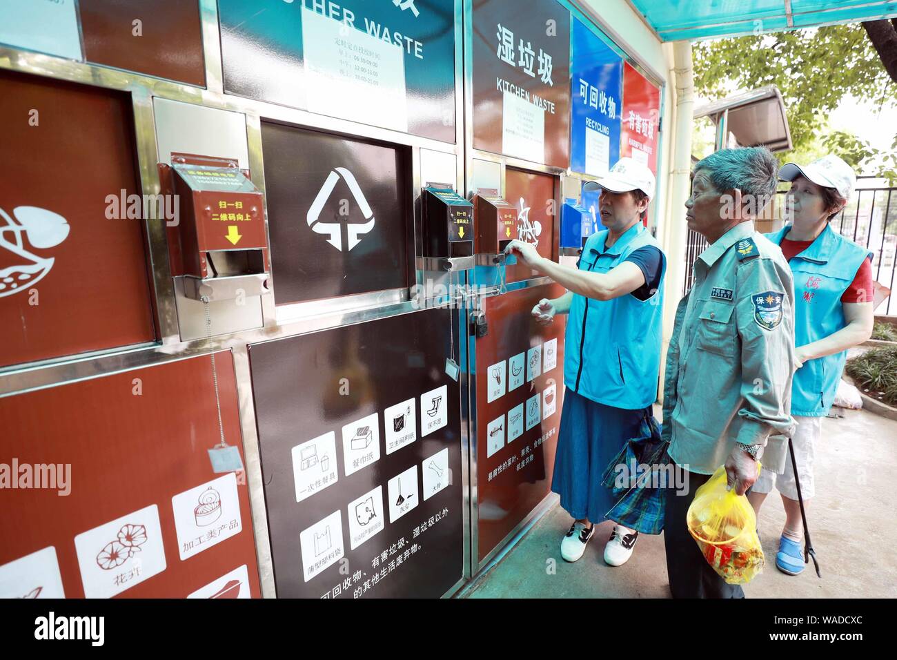 An elderly man throws rubbish into different bins deployed to meet the ...