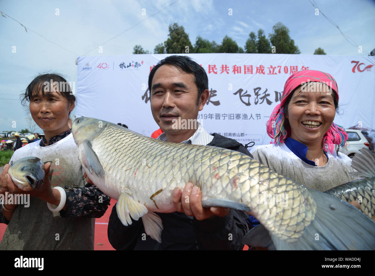 Local residents show fish they caught during the Jiuzhai Fishing ...