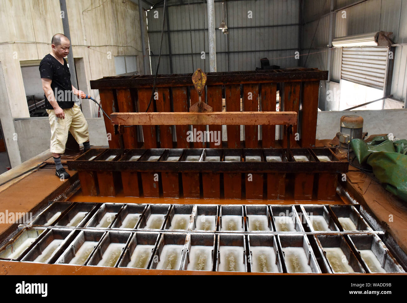 Chinese workers manufacture ice blocks at a factory in Chaohu city ...
