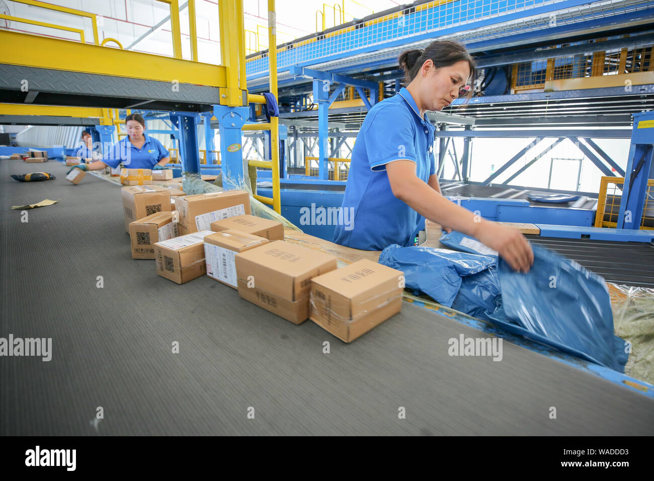 Employees work along assemble line to dispatch packages with computer ...