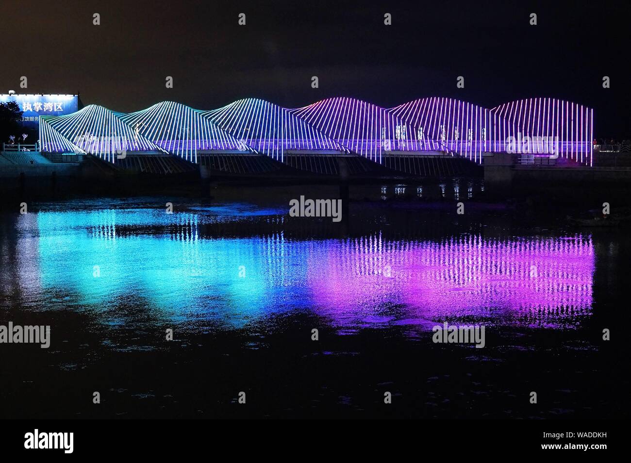Local residents walk on the Rainbow Bridge illuminated by colorful ...