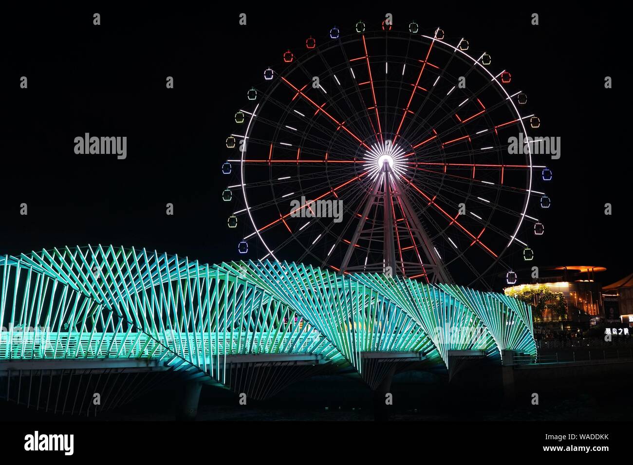 Local residents walk on the Rainbow Bridge illuminated by colorful ...