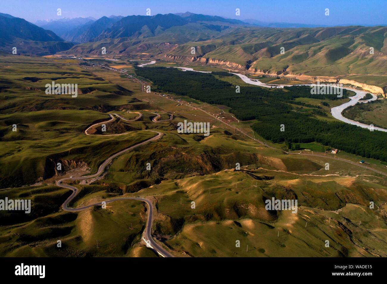 Cars drive on a spiral undulating mountain road at the Kalajun Scenic ...