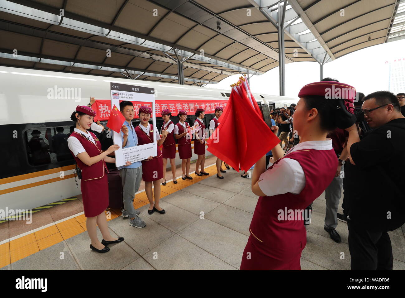 Chinese train attendants pose with a passenger in front of the first ...