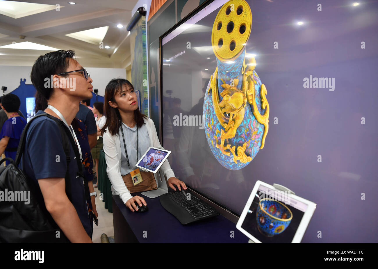Visitors view a digital product at the Palace Museum, also known as the ...