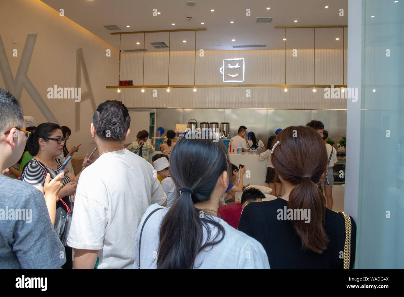 Chinese fans wait in a long queue in front of a milk tea store operated ...