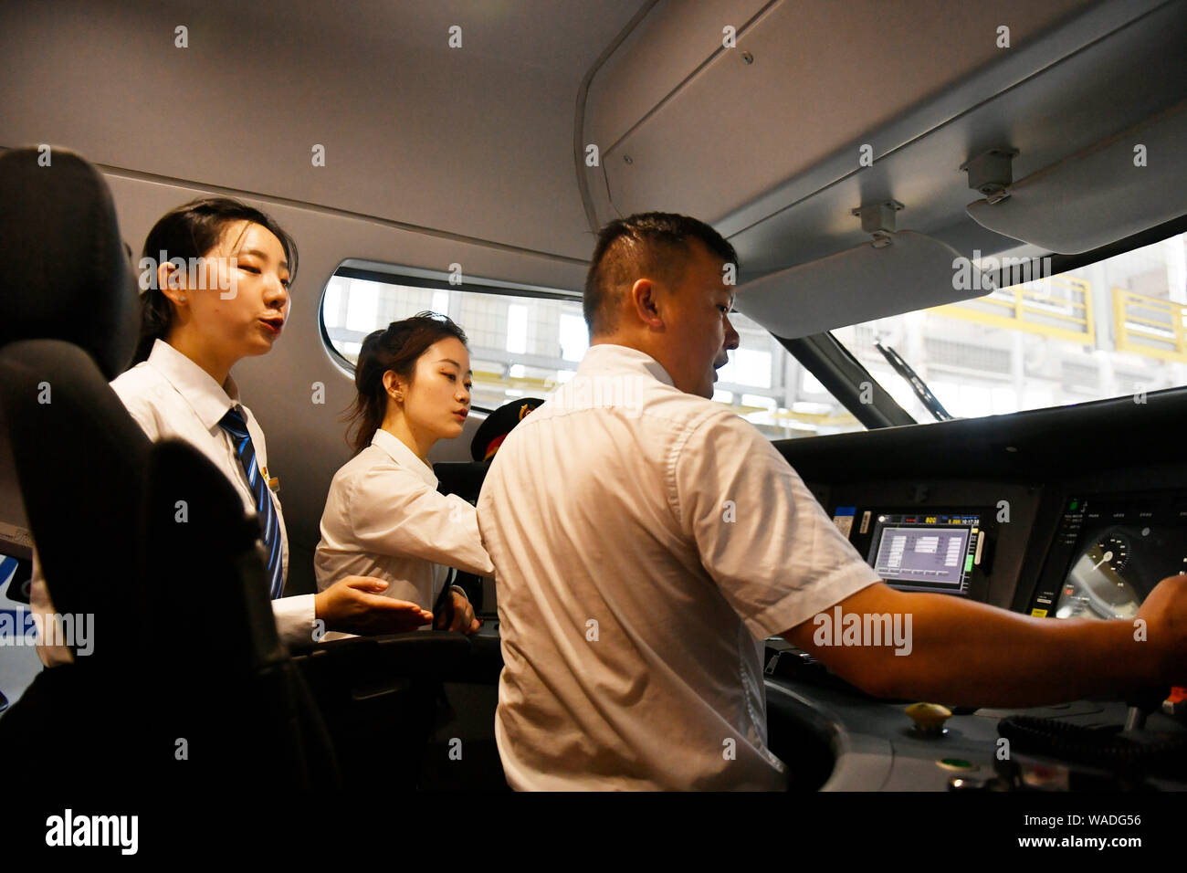 Two Chinese female trainee drivers learn from an experienced driver in ...