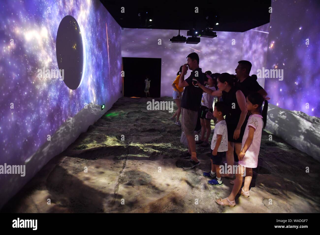Chinese parents and their kids view the simulated lunar surface during ...