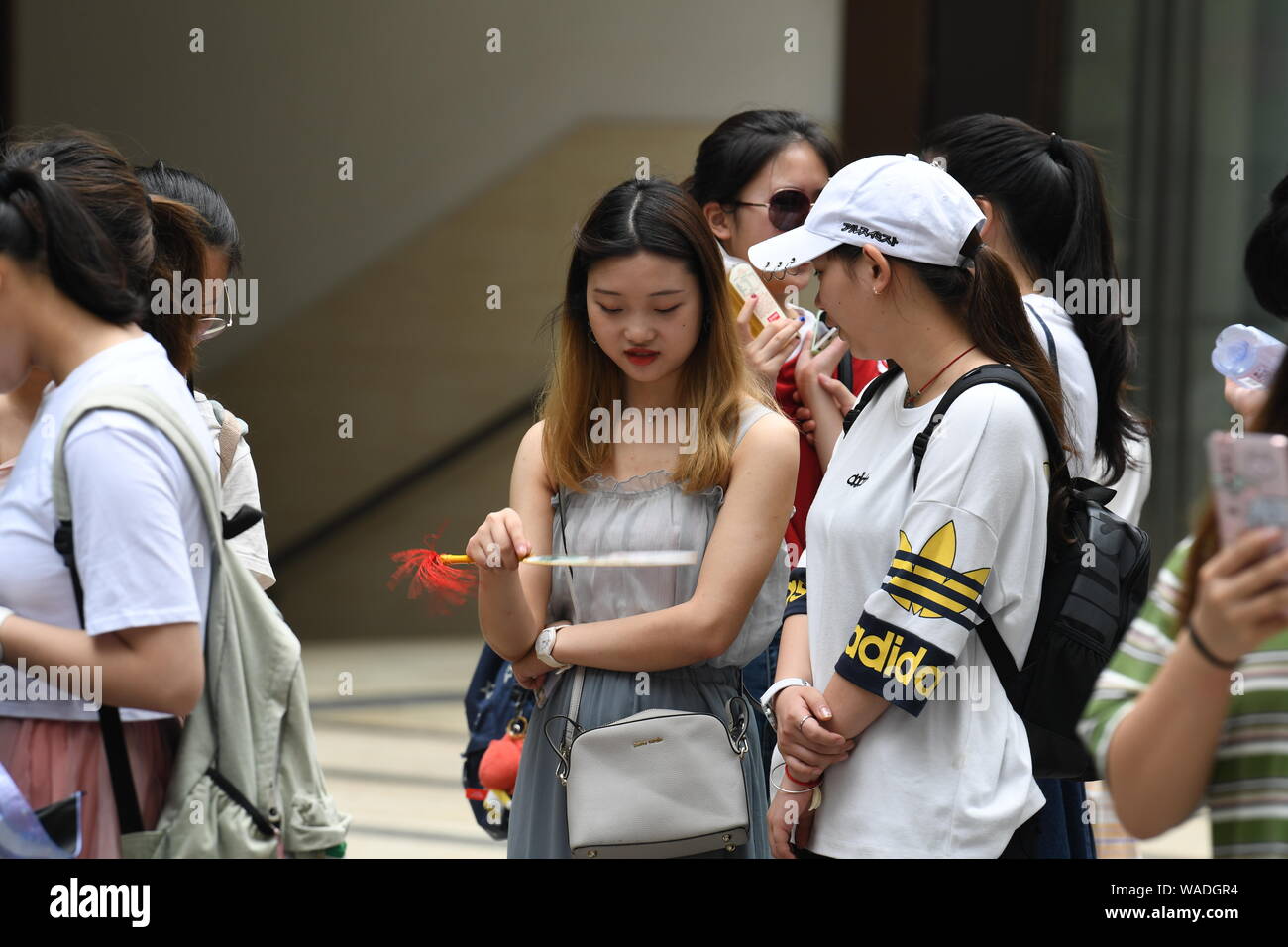 Chinese fans wait in a long queue in front of a milk tea store operated ...