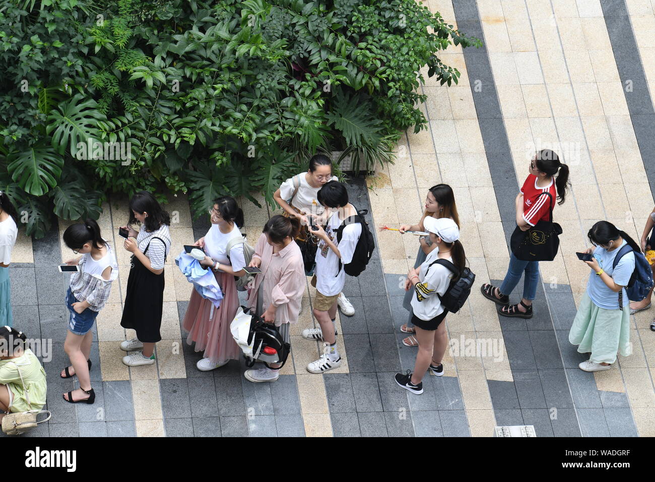 Chinese fans wait in a long queue in front of a milk tea store operated ...