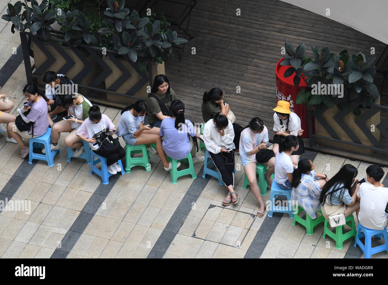 Chinese fans wait in a long queue in front of a milk tea store operated ...