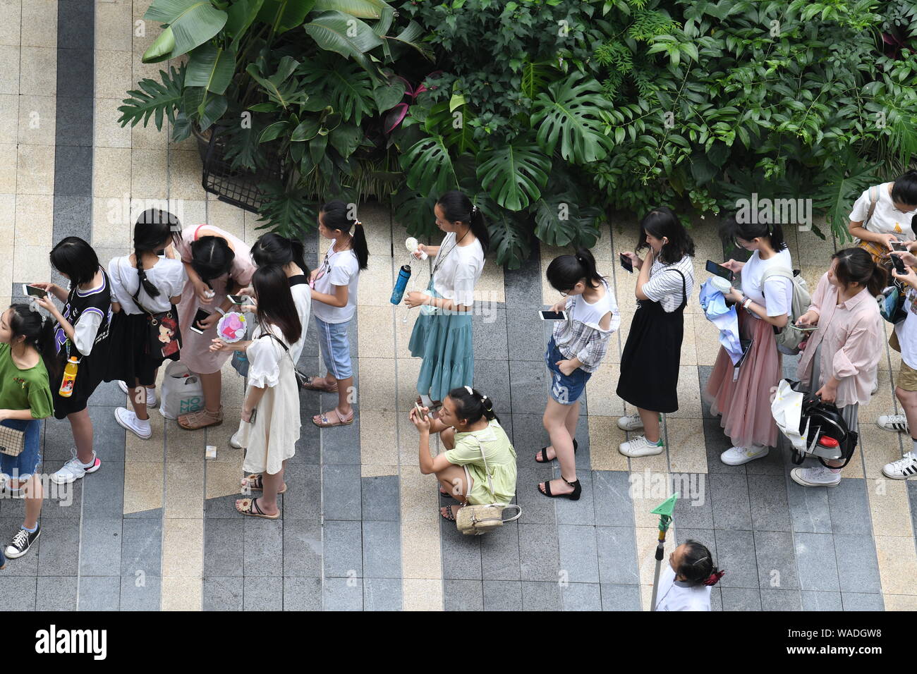 Chinese fans wait in a long queue in front of a milk tea store operated ...