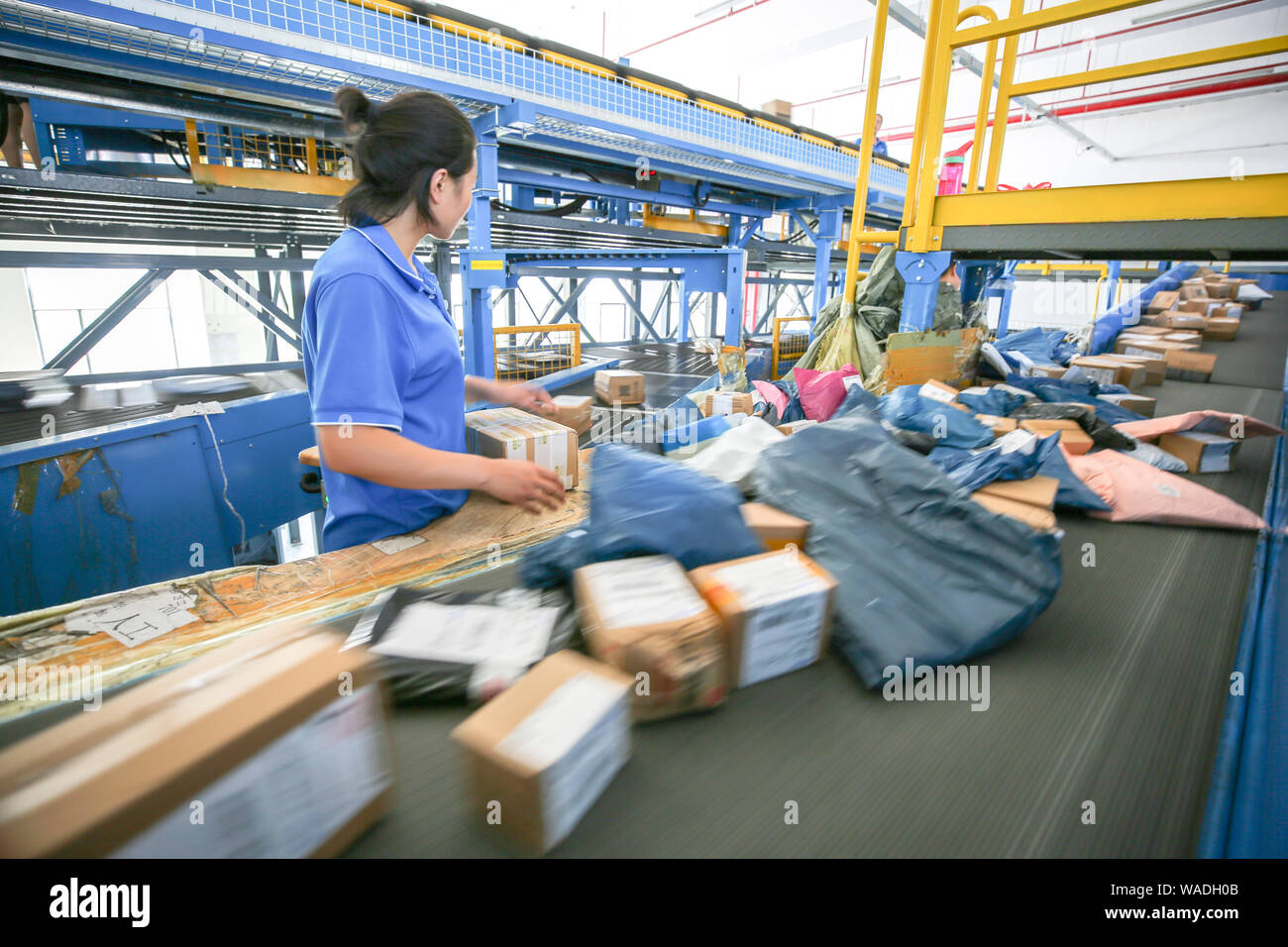 Employees work along assemble line to dispatch packages with computer ...