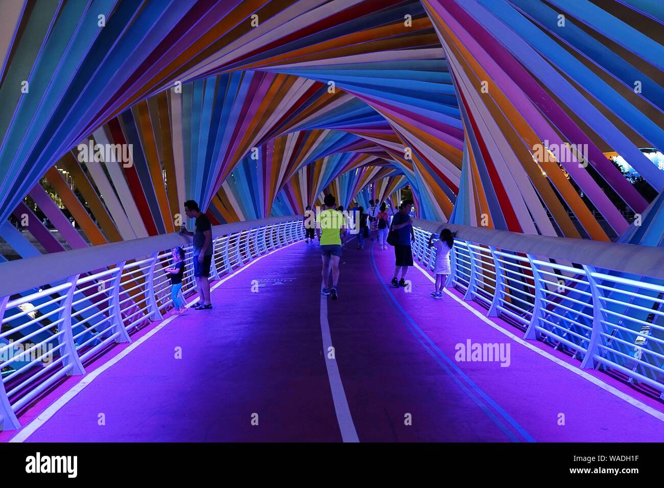 Local residents walk on the Rainbow Bridge illuminated by colorful ...