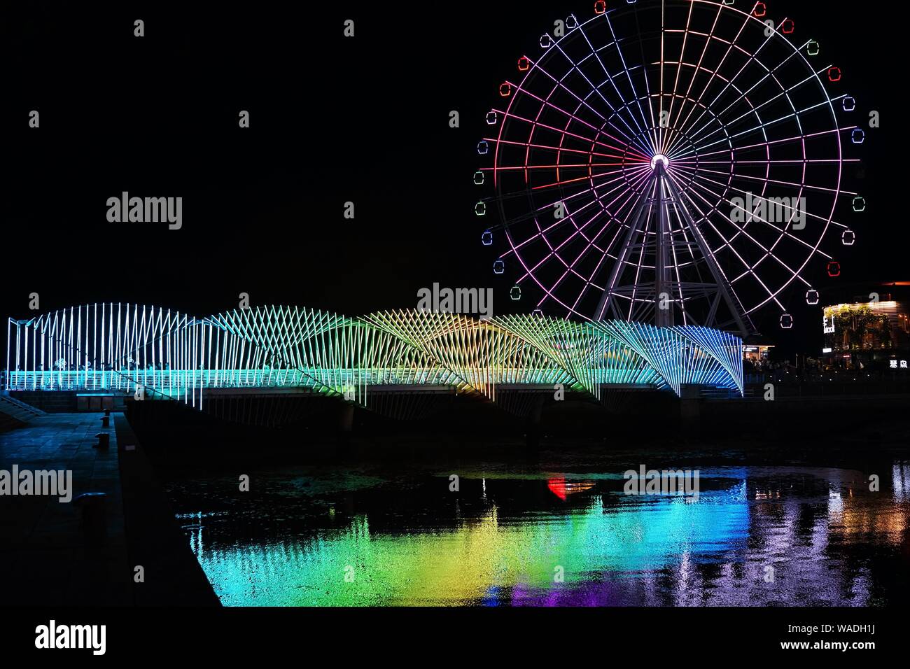Local residents walk on the Rainbow Bridge illuminated by colorful ...
