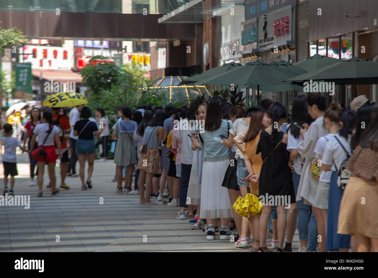 Chinese fans wait in a long queue in front of a milk tea store operated ...