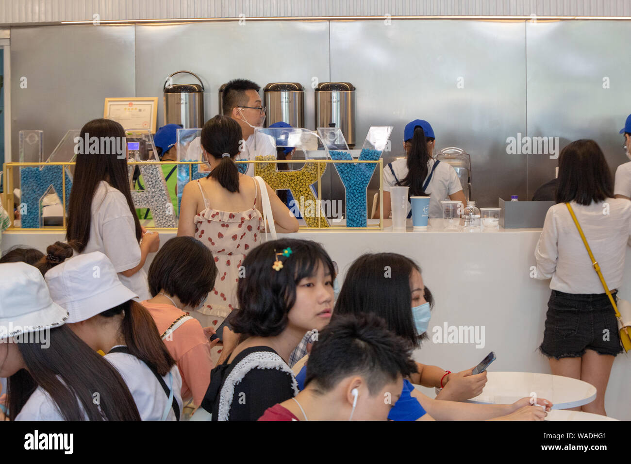 Chinese fans wait in a long queue in front of a milk tea store operated ...