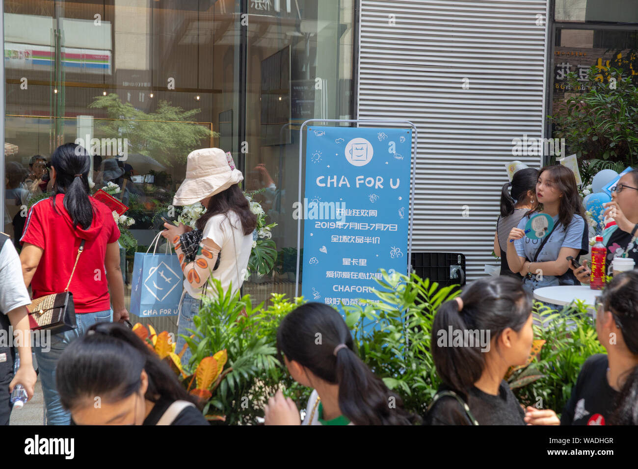Chinese fans wait in a long queue in front of a milk tea store operated ...