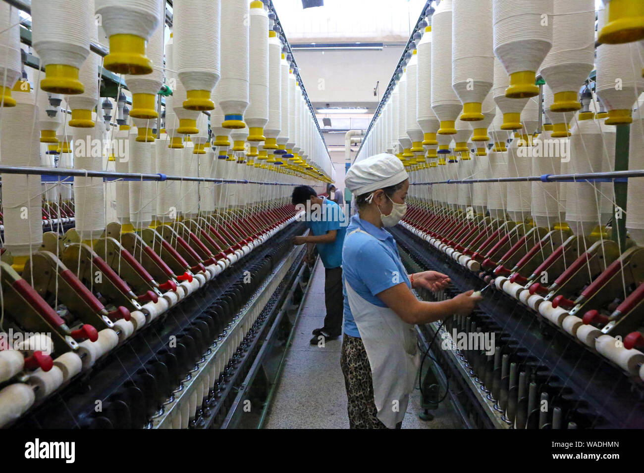 --FILE--Chinese workers handle production of yarn at a textile factory ...