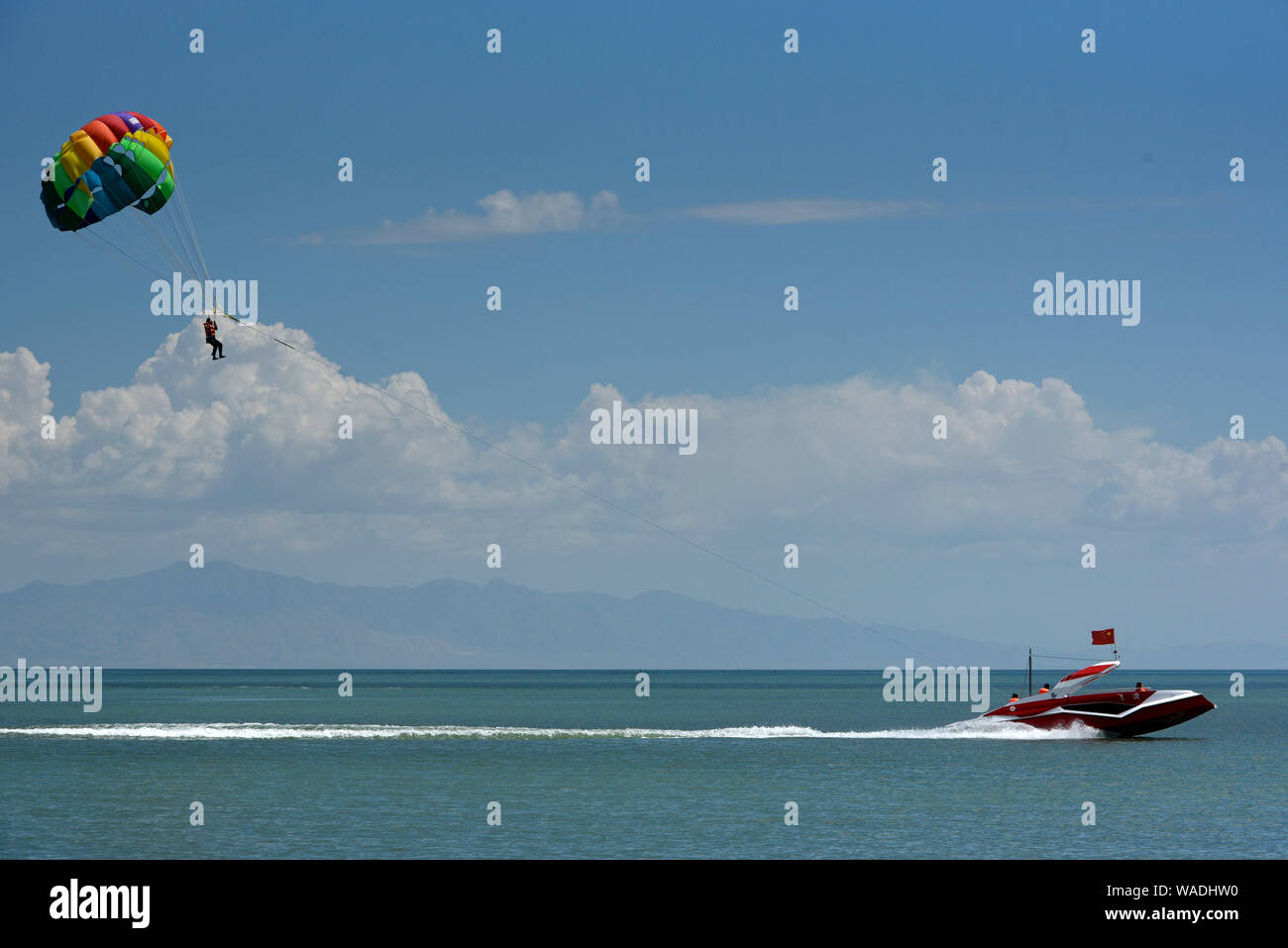 A tourist tries out flying paraglider above the Bosten Lake, one of the ...