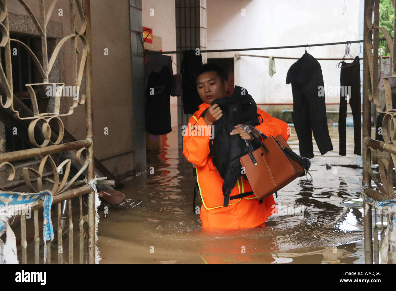A Chinese rescuer evacuates valuables in floodwater caused by a heavy ...