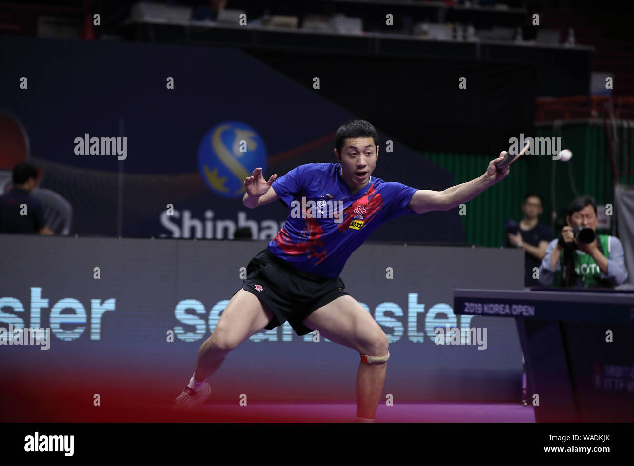 Xu Xin of China returns a shot to Lim Jonghoon and Yoo Eunchong of South Korea in the ...
