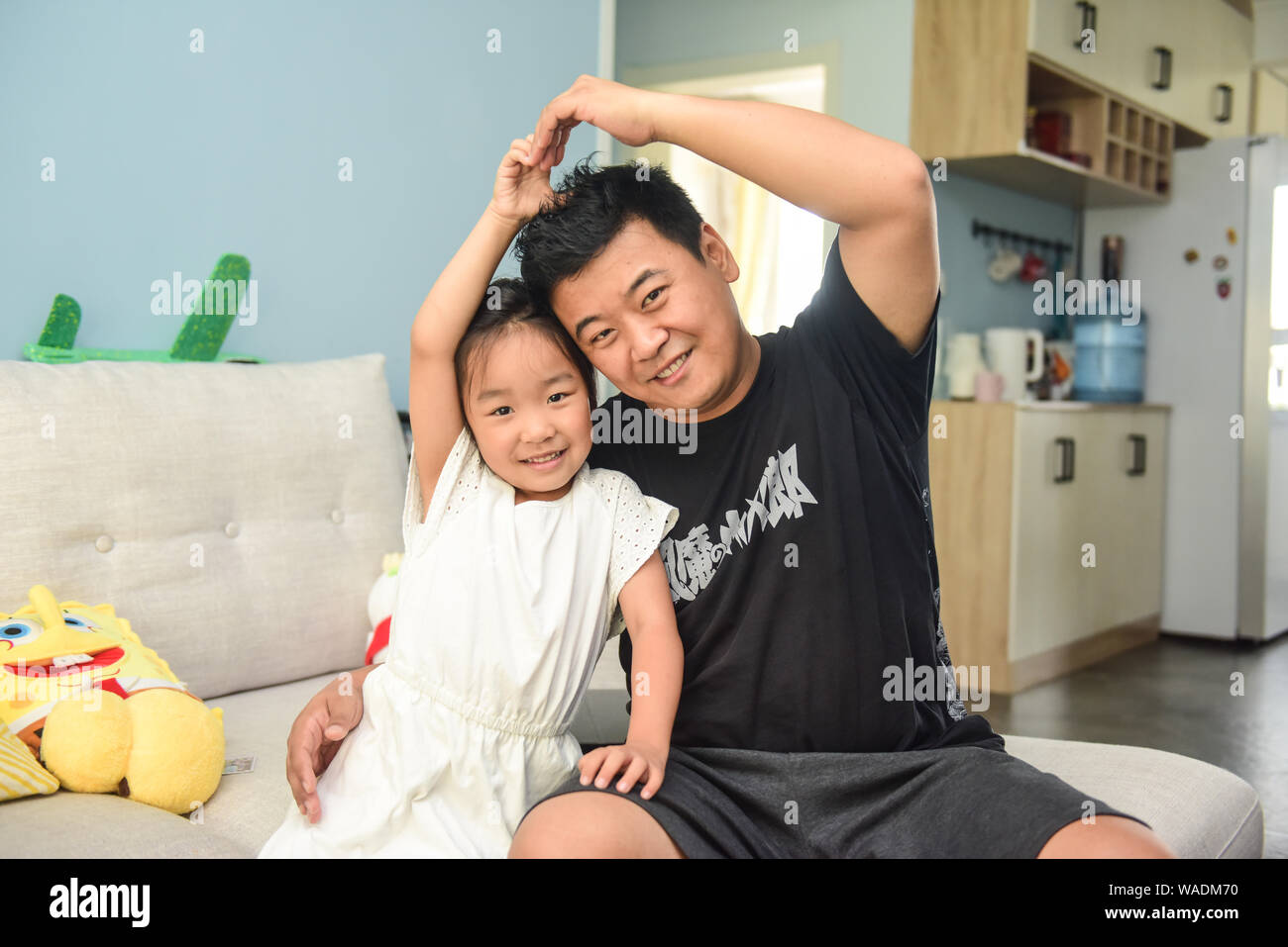 Chinese cartoonist Cheng Peng and his daughter pose for photos at home ...