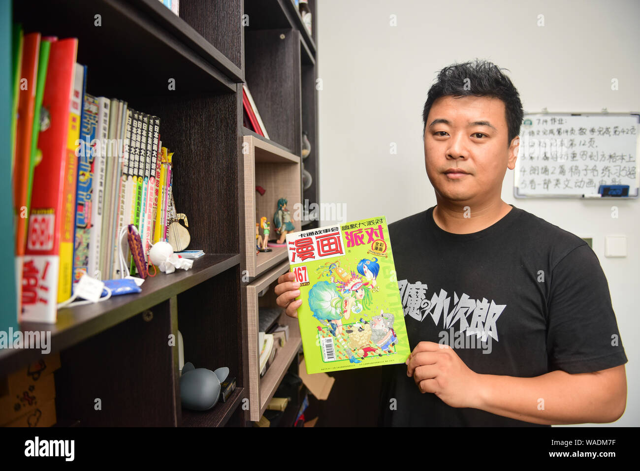 Chinese cartoonist Cheng Peng poses for photos with a book of fairy ...