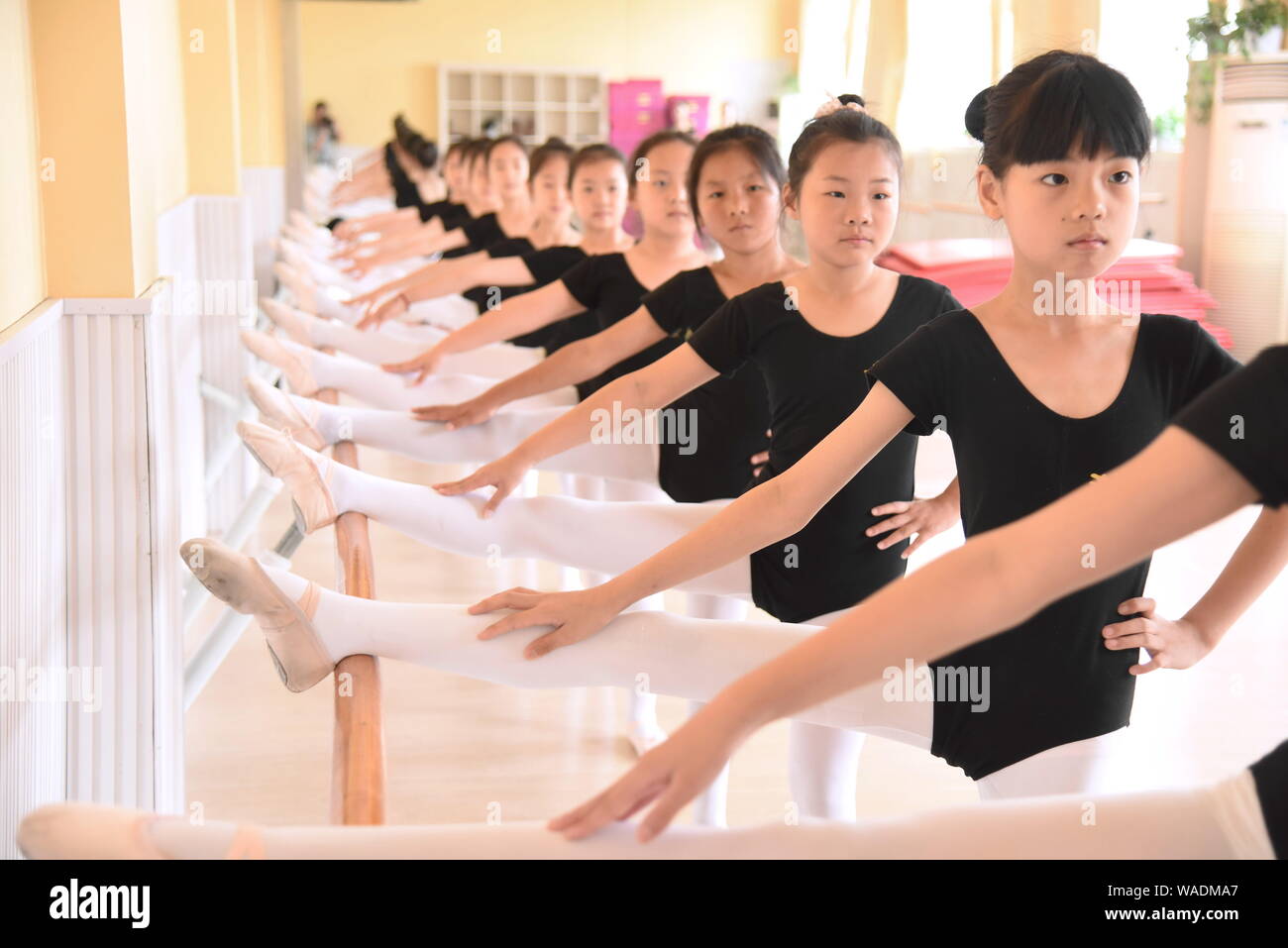 Young girls practice dancing skills during a training session at a ...