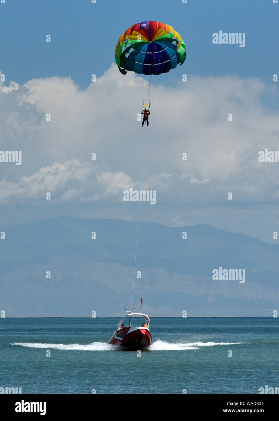 A tourist tries out flying paraglider above the Bosten Lake, one of the ...